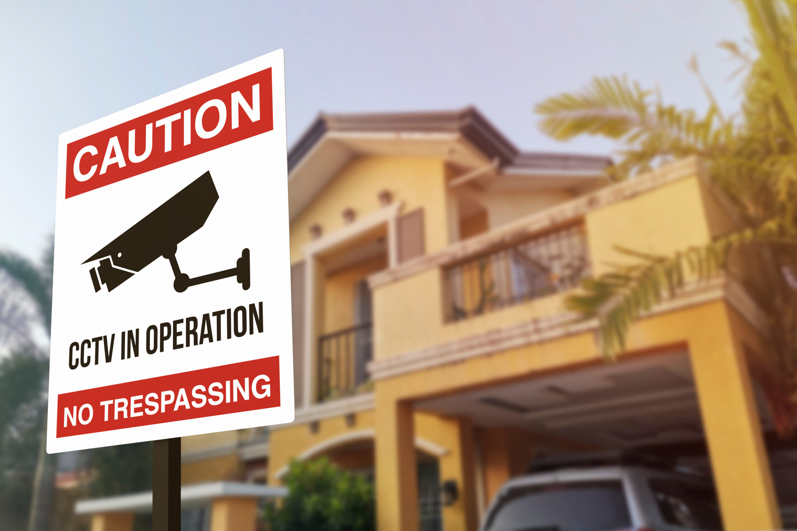 A CCTV sign in front of a gated home. Warning to visitors or burglars ...